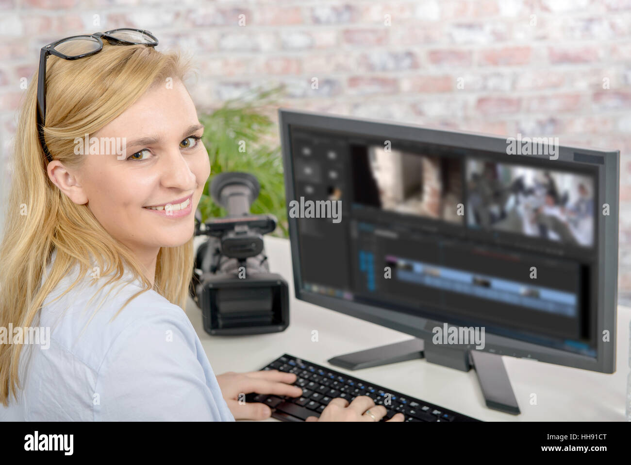 young blonde female designer using graphics tablet for video editing ...