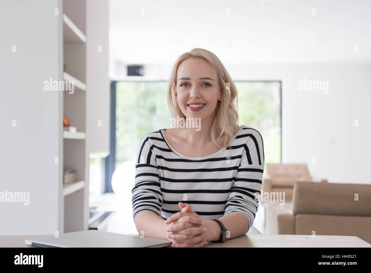 Young woman with her laptop computer in her luxury modern home, smiling ...