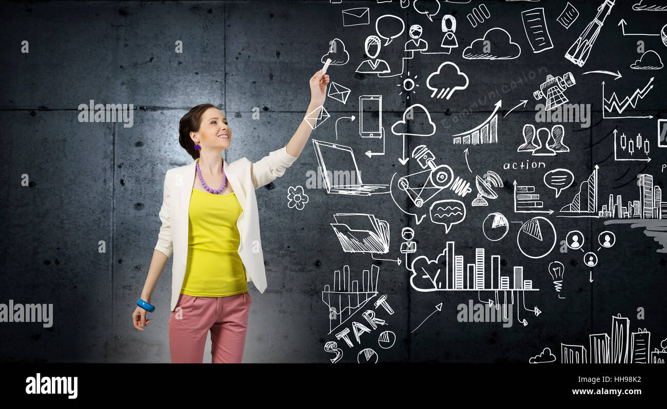 Young pretty woman drawing with chalk her vision of success achieving ...