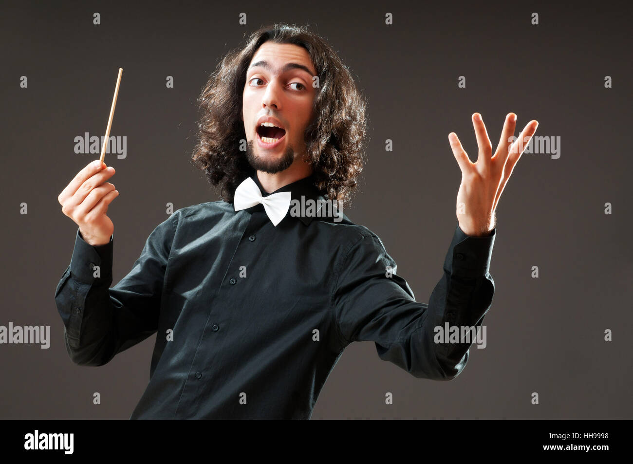 Funny conductor against dark background Stock Photo - Alamy
