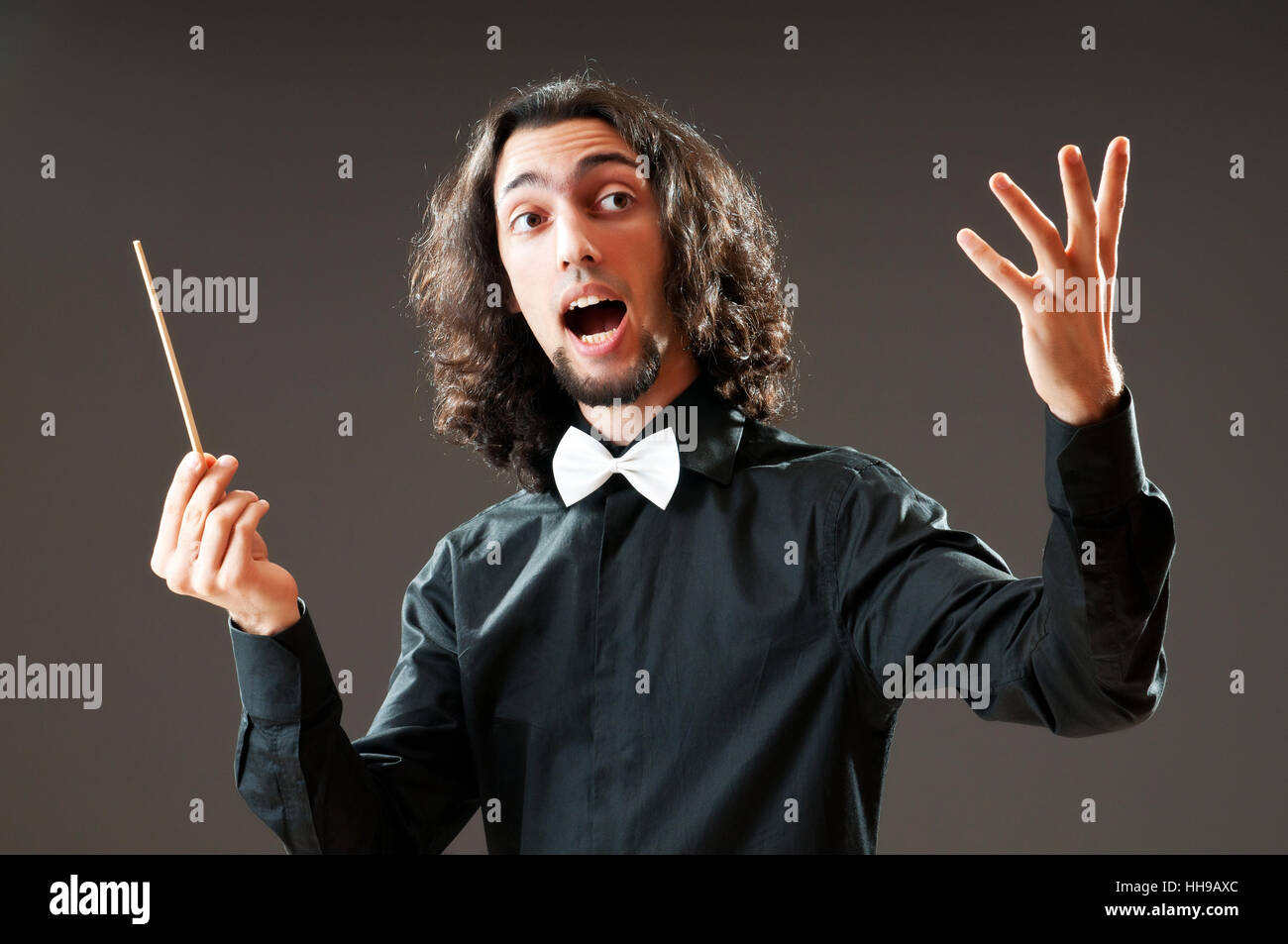 Funny conductor against dark background Stock Photo - Alamy
