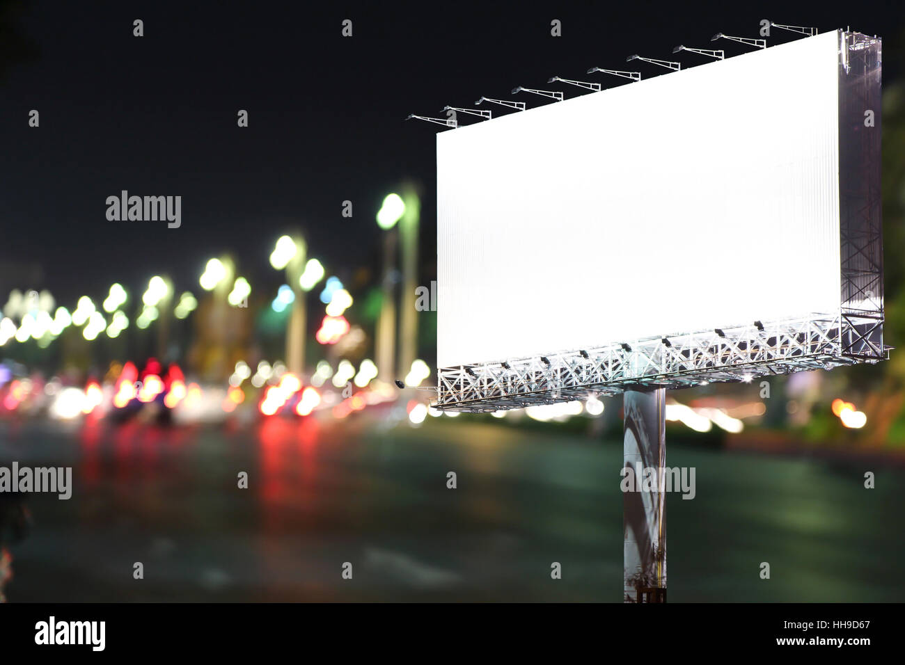 Blank billboard on blurred abstract night street - can advertisement ...