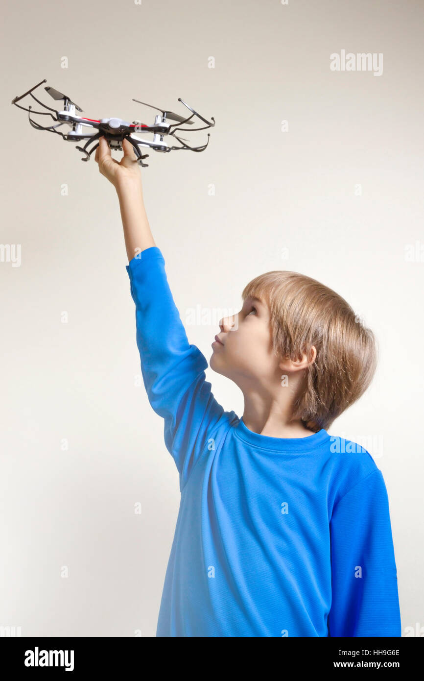Little kid playing with drone. Boy holding quadcopter in his hand ...
