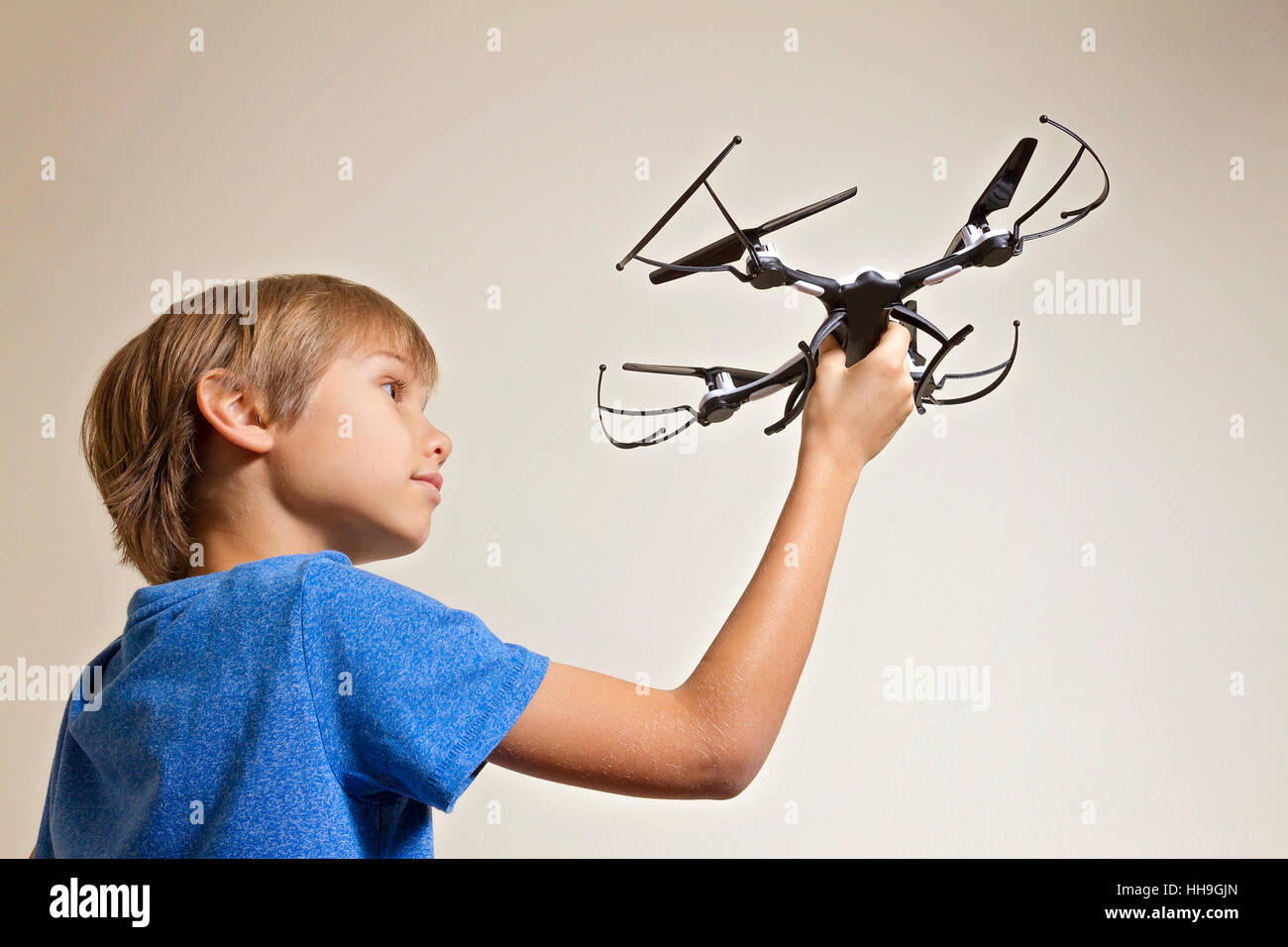 Schoolboy kid playing with drone. Boy holding quadcopter in his hand ...