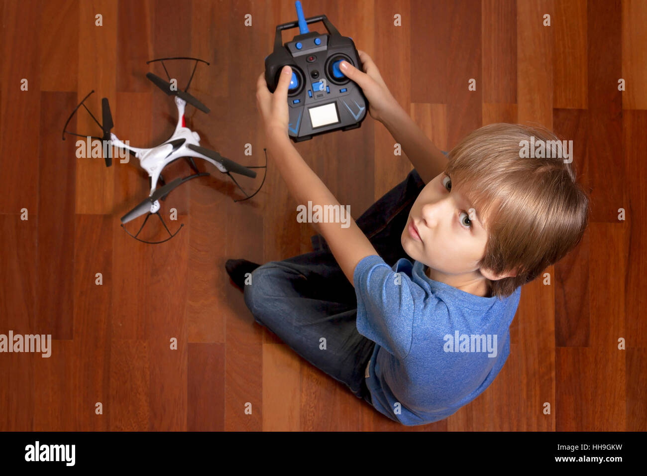 Little kid is going to play with the quadcopter drone at home. Boy ...