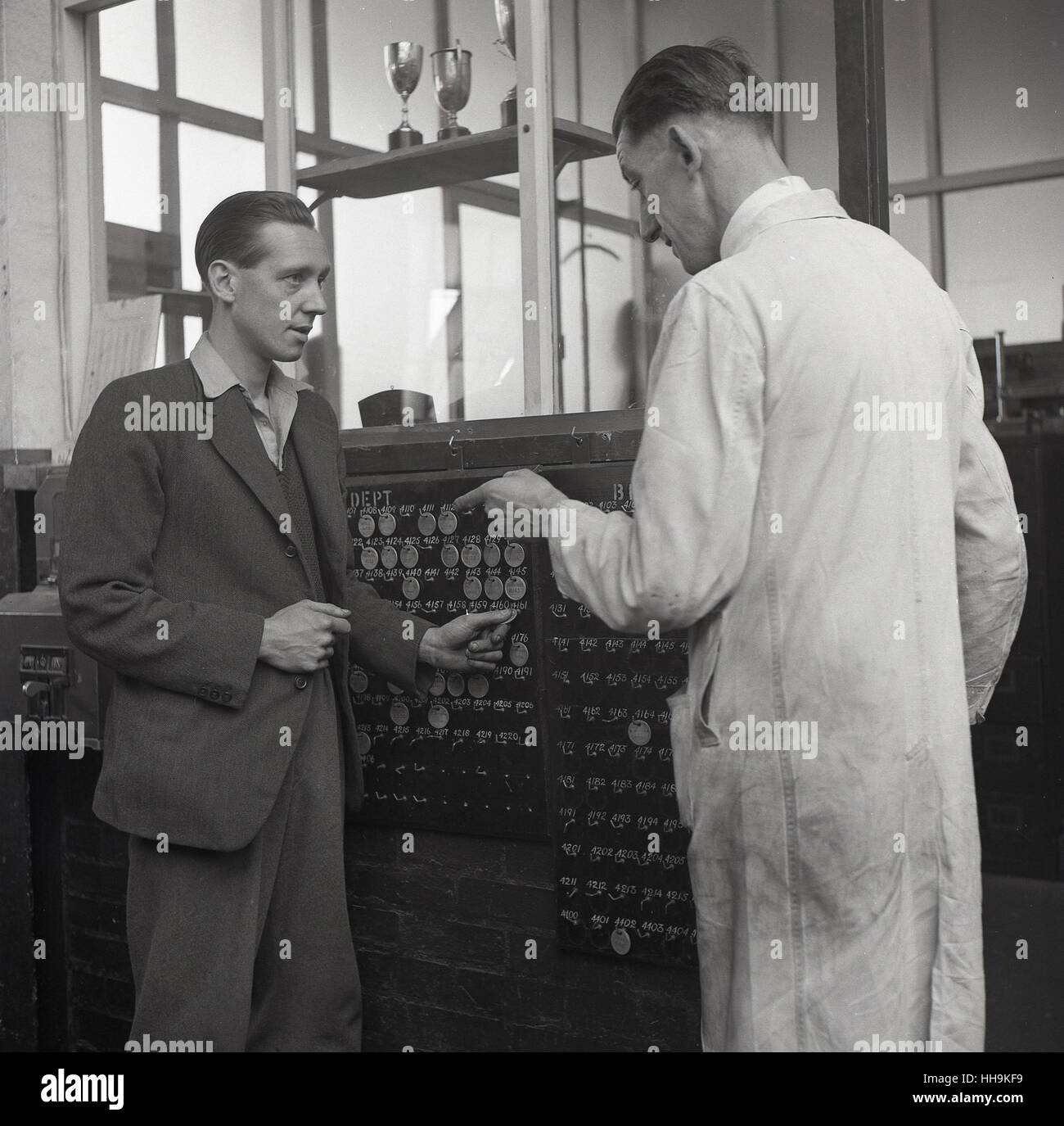 1950s, historical, factory foreman talks to male worker warning him of ...