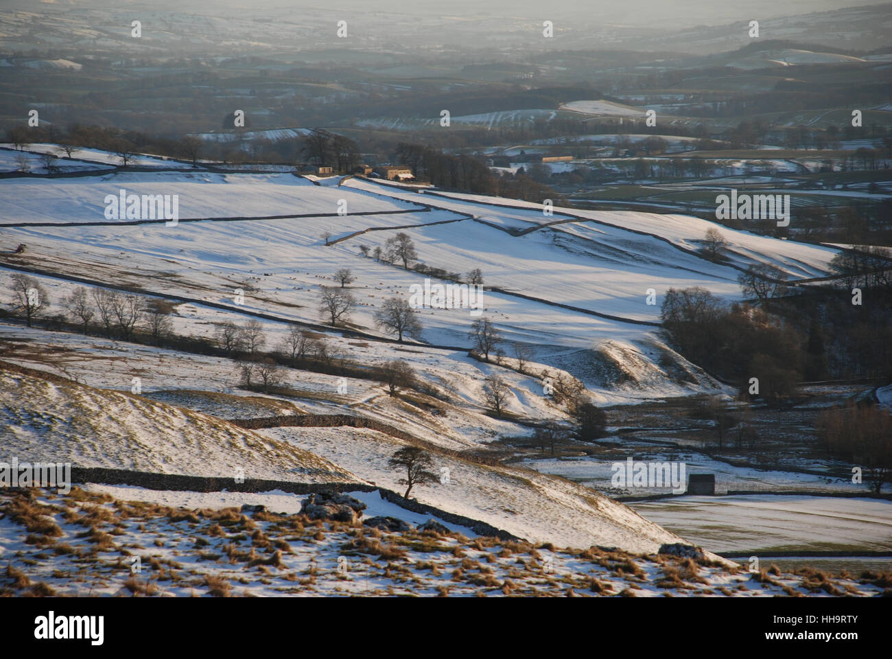 Snow covered winter landscape with the glow from a setting sun near ...