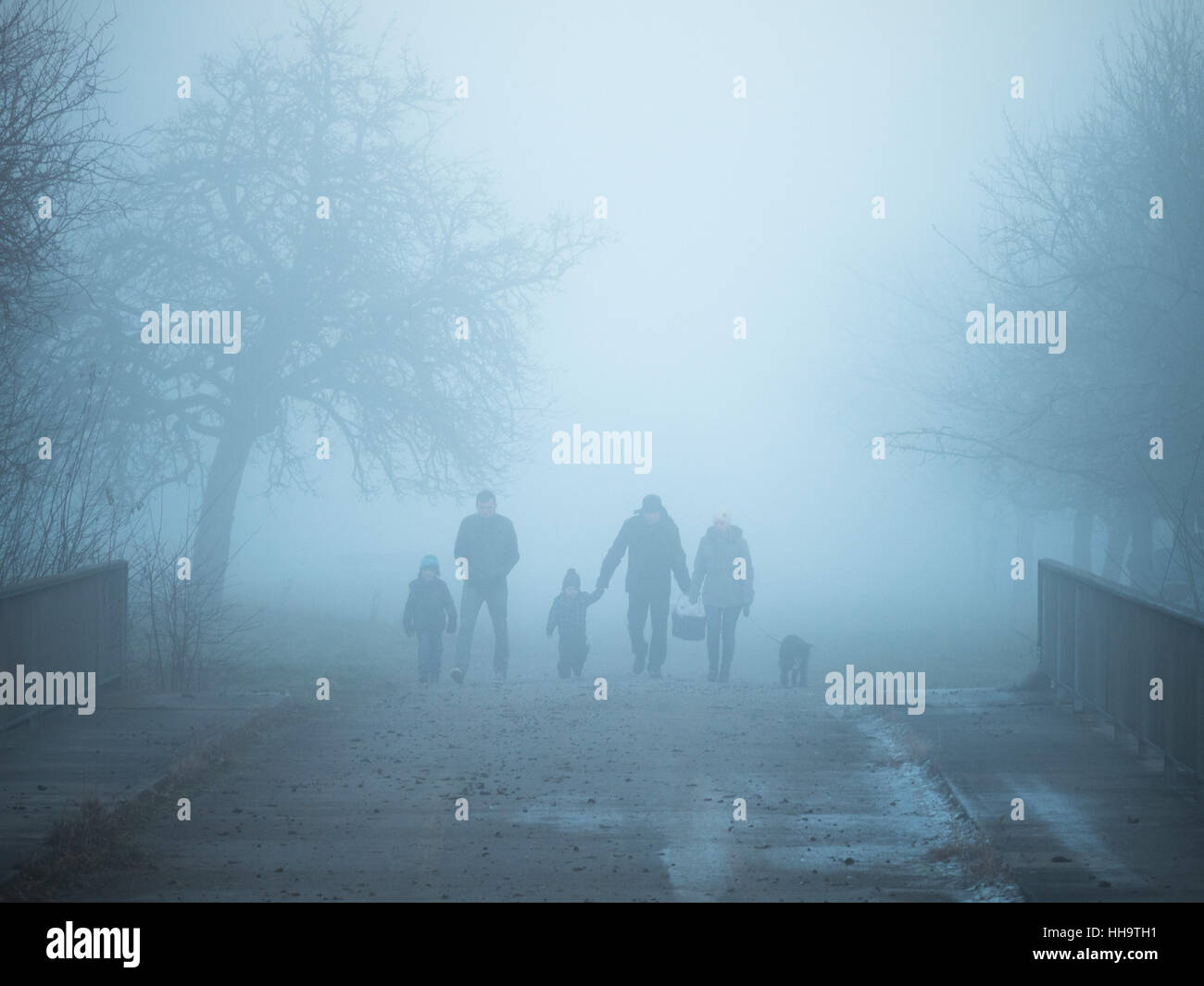 A Family and a dog walking through a cold and misty November day Stock ...