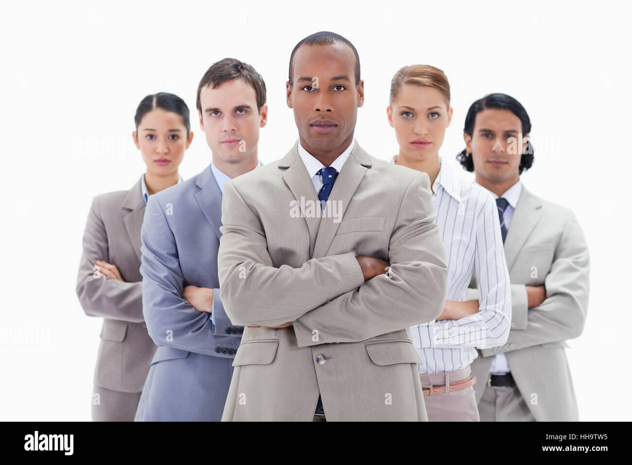 Close-up of a serious business team crossing their arms against white ...