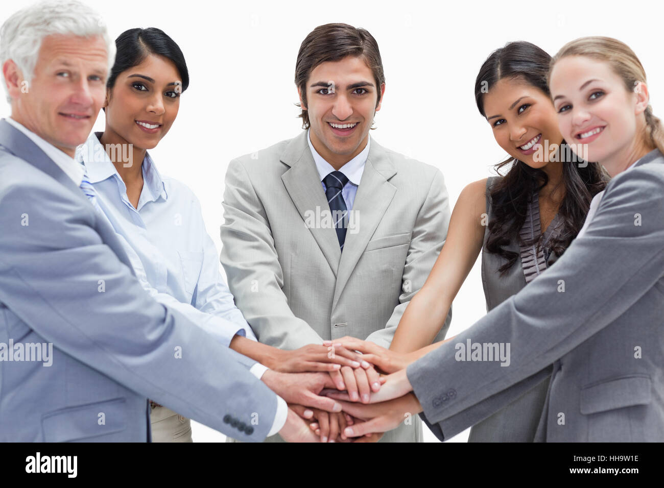 Close-up of people putting their hands on each others against white ...