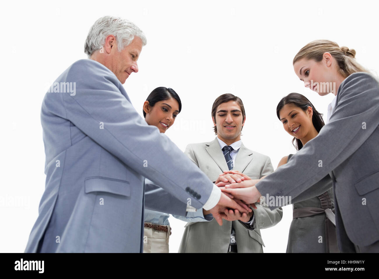 Team putting their hands on each others against white background Stock ...