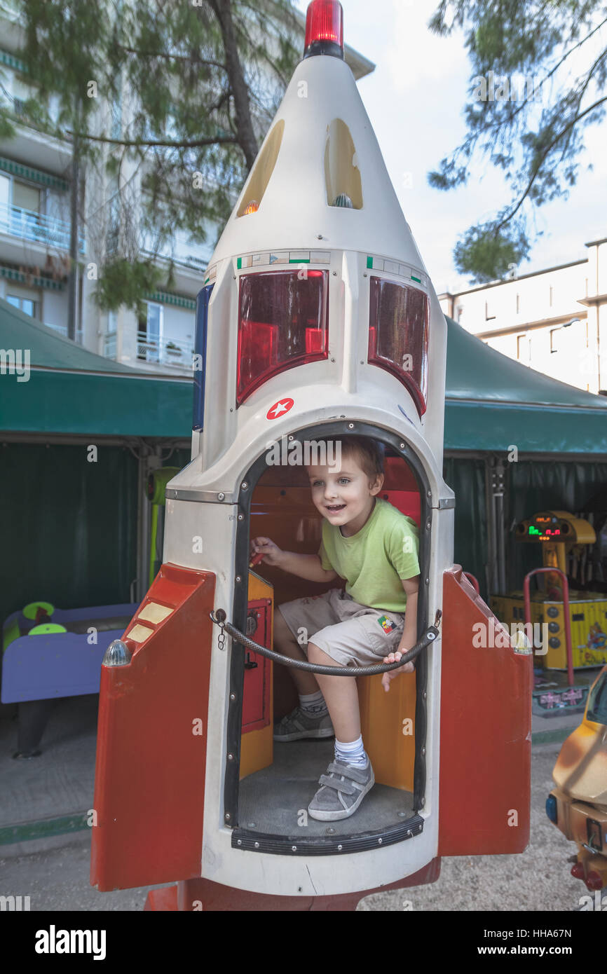 Little boy having fun inside a rocket carousel Stock Photo - Alamy