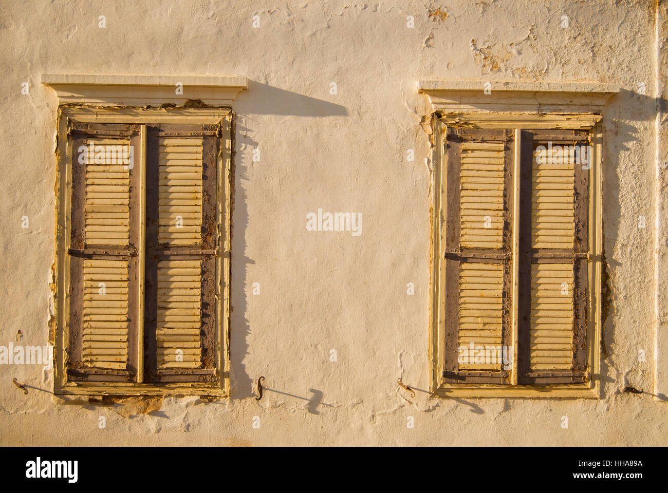 Window shutters and walls of a run down house on the island of Symi ...