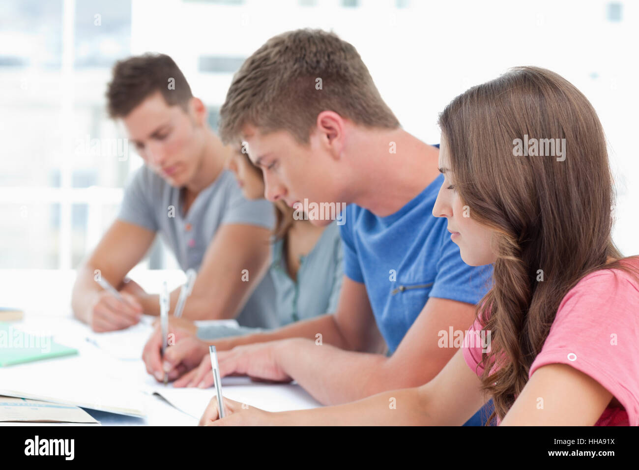 A side view shot of a group of students working hard Stock Photo - Alamy