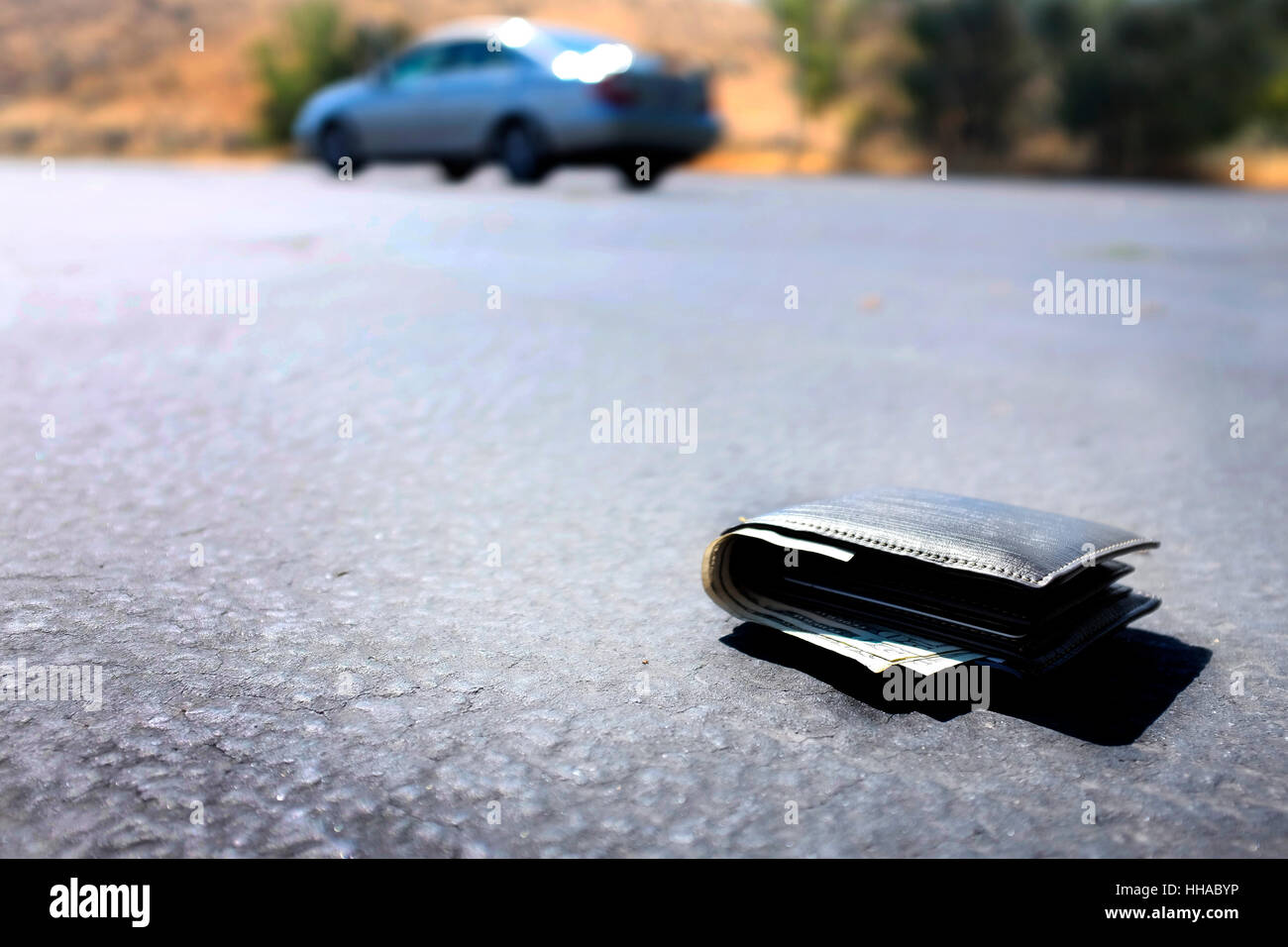 Wallet fallen out of car on roadway road Stock Photo - Alamy