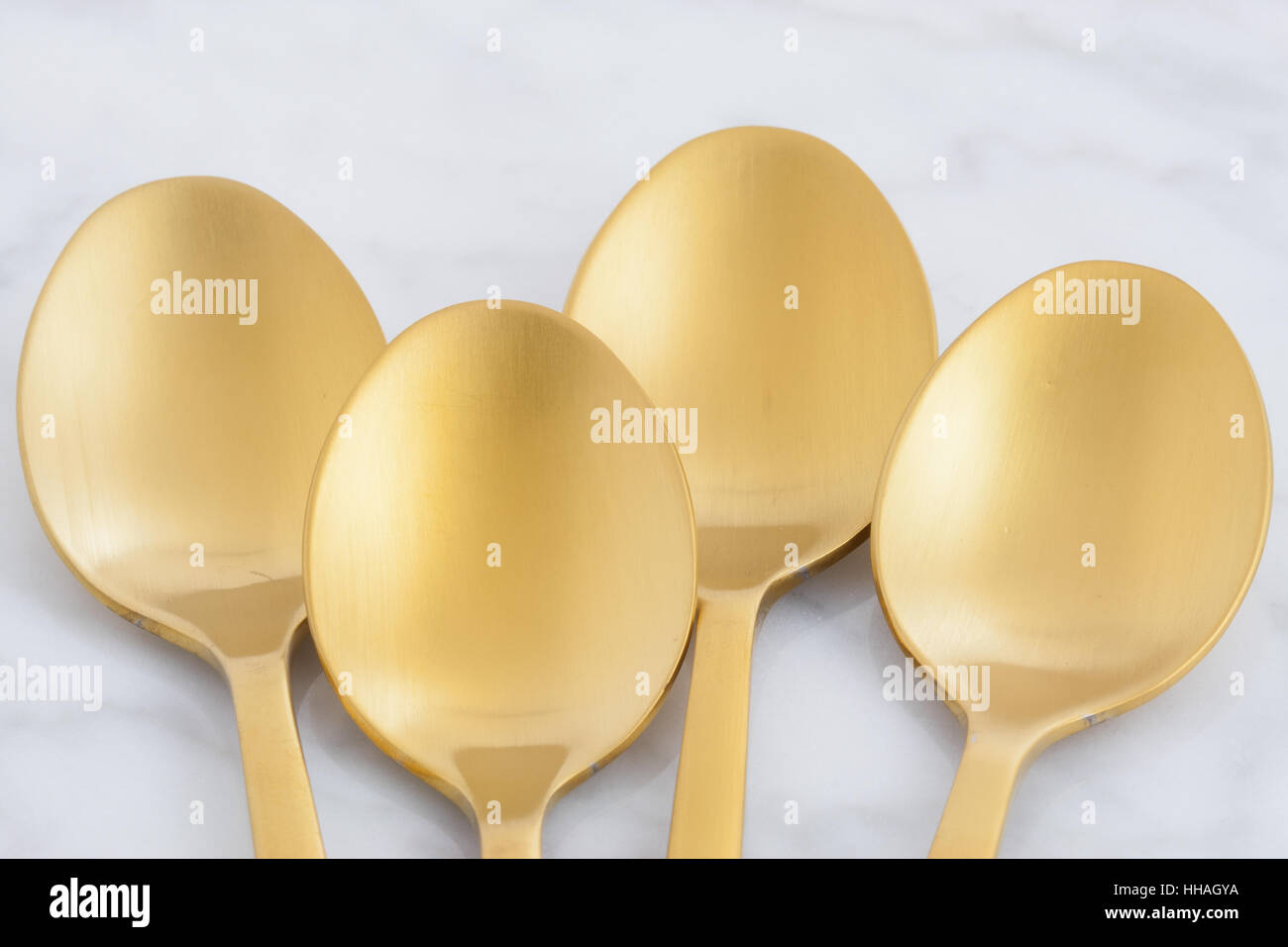 golden spoon set styled on antique carrara marble Stock Photo - Alamy