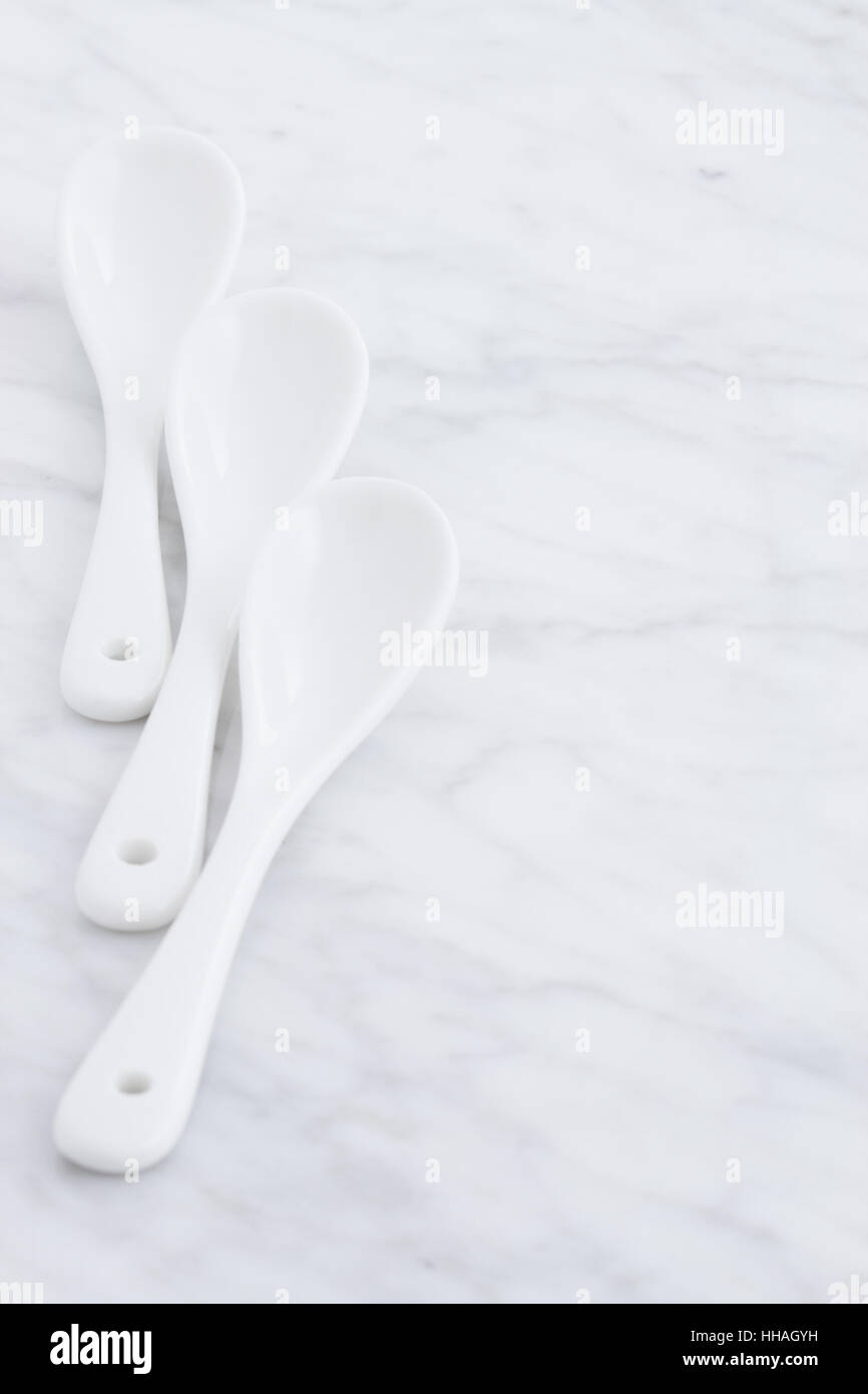 white spoon set styled on antique carrara marble Stock Photo - Alamy
