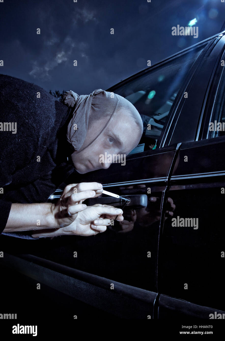 Car thief stealing a car by picking a lock at night Stock Photo - Alamy