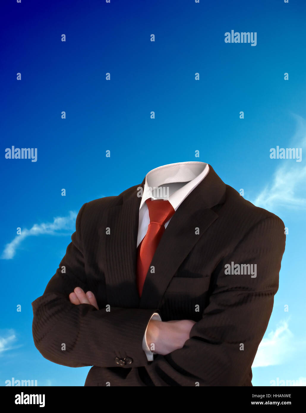 business man without a head and crossed arms in front of perfect blue ...