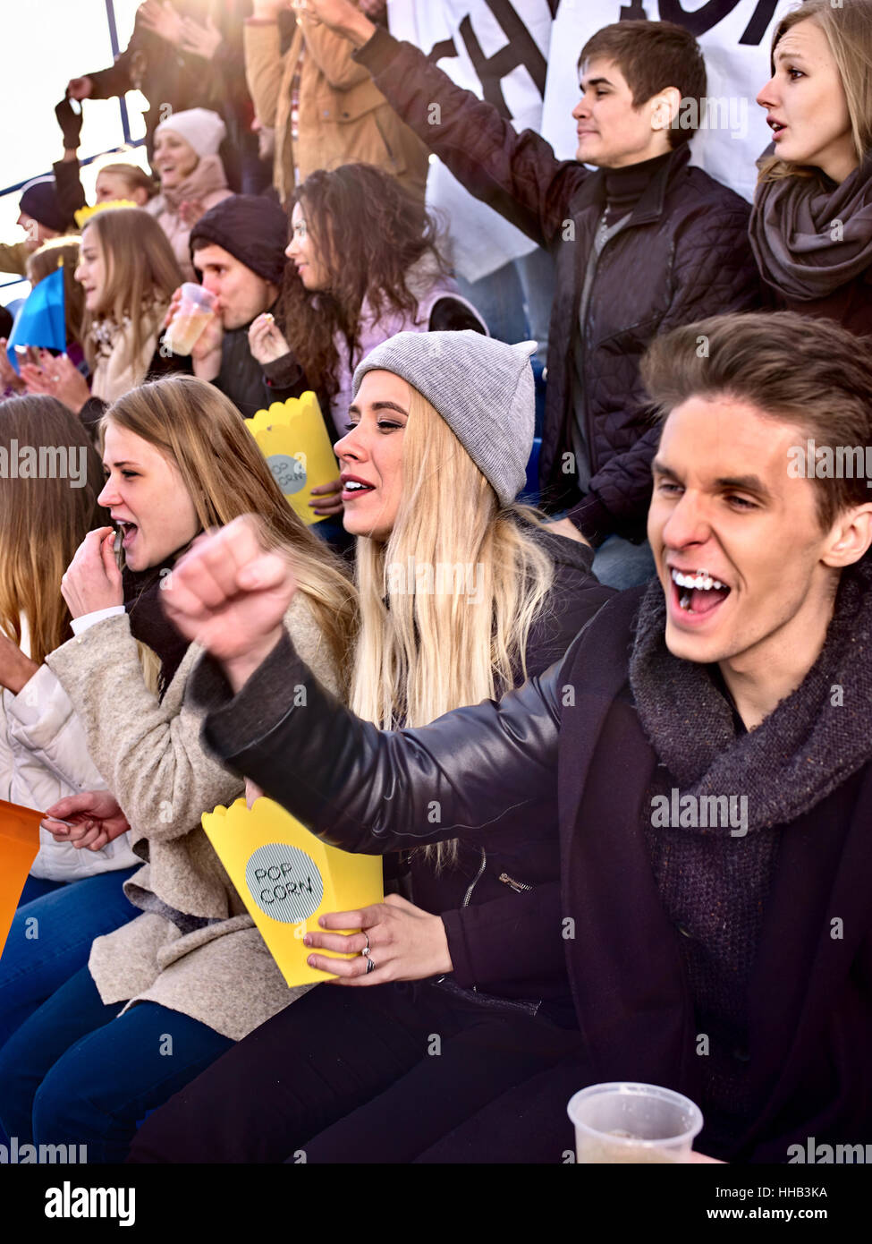 Fans cheering in stadium and eating popcorn Stock Photo - Alamy