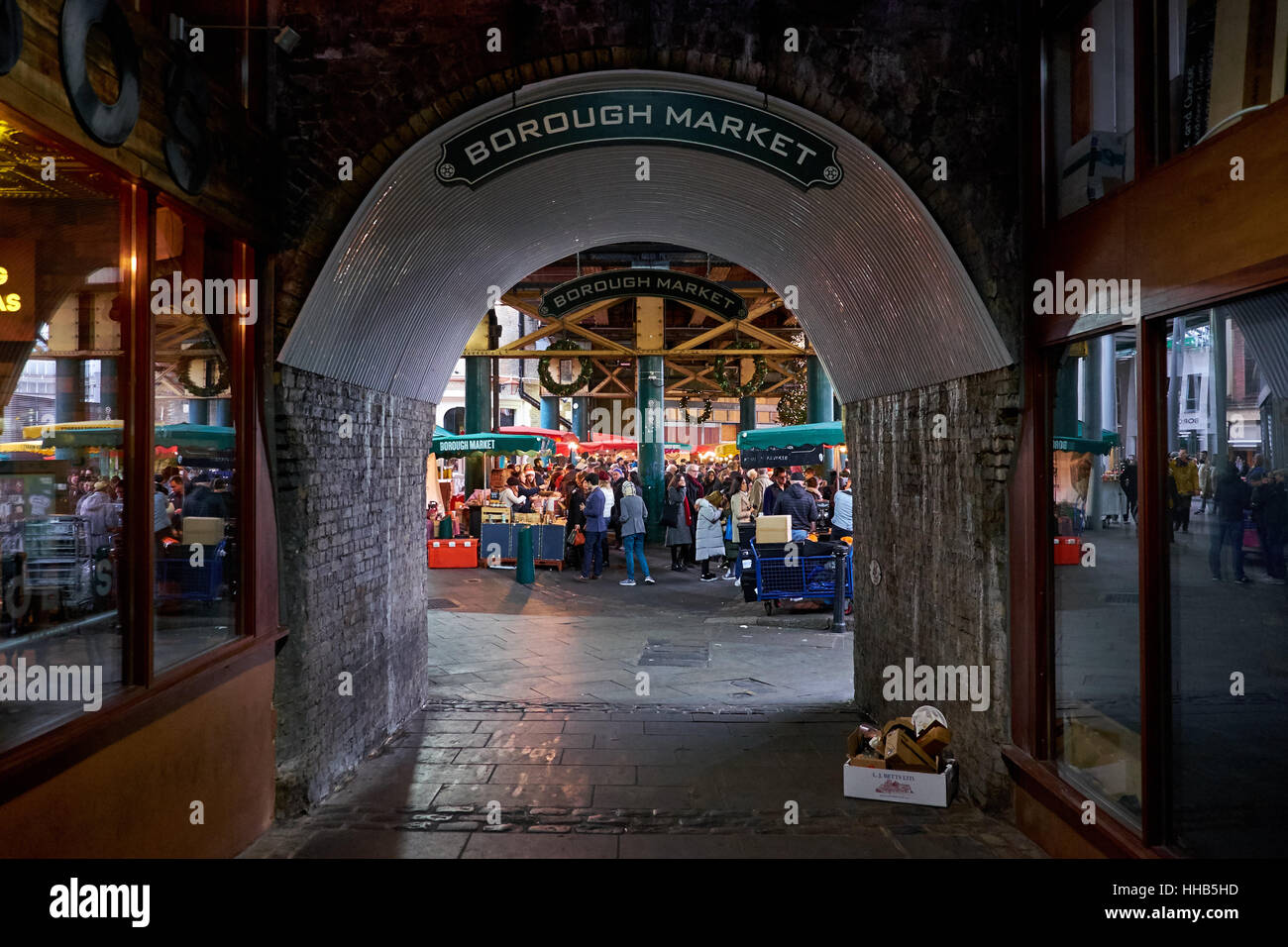 Entrance with hanging signs to Borough Market under the railway tracks ...