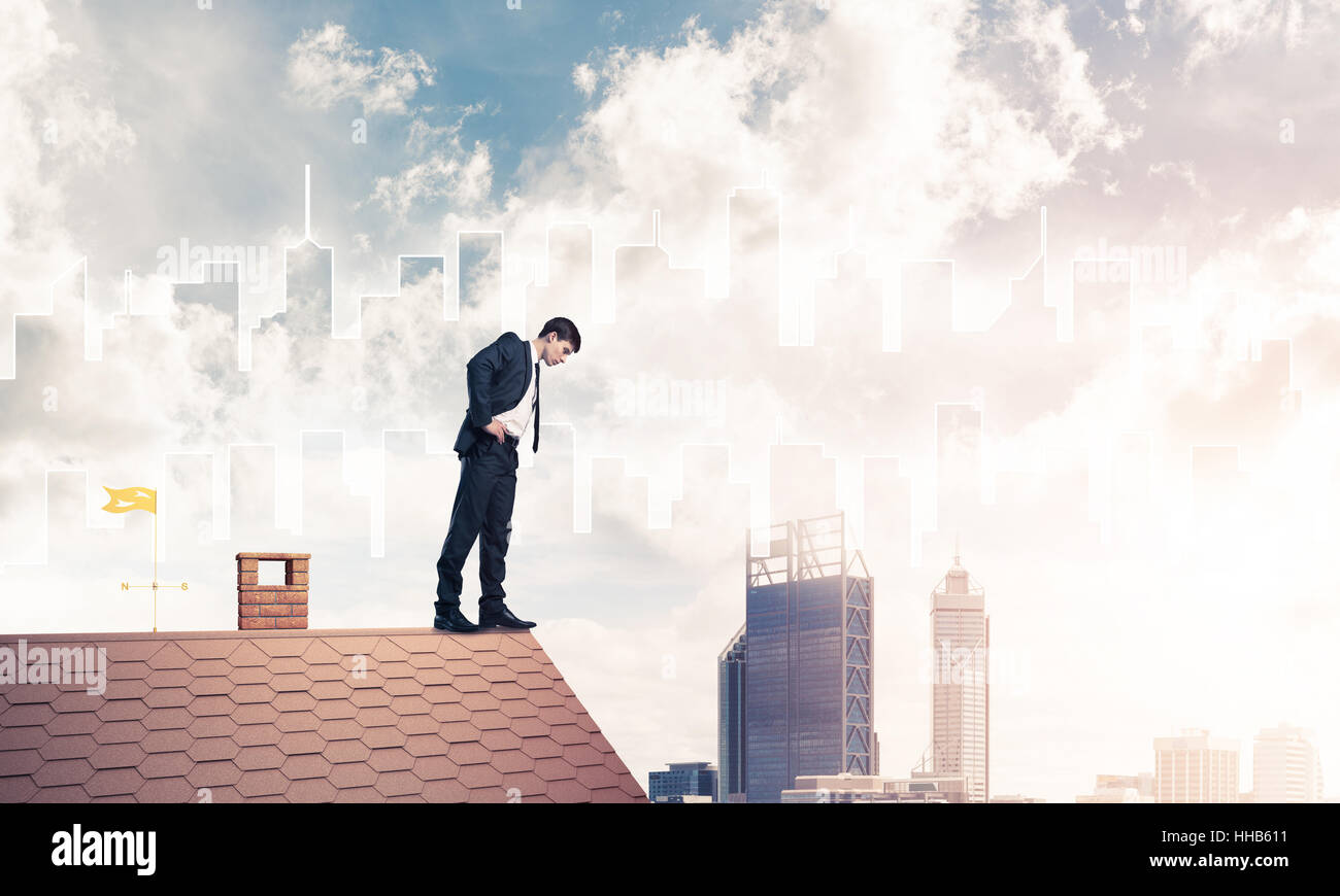 Businessman looking down from roof and modern cityscape at backg Stock ...