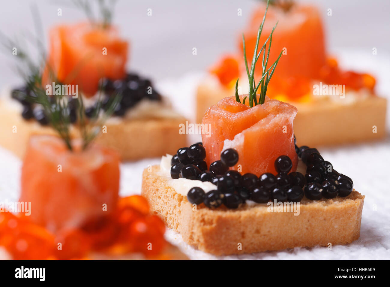 Canapes with black sturgeon caviar and salmon fish. macro. horizontal ...