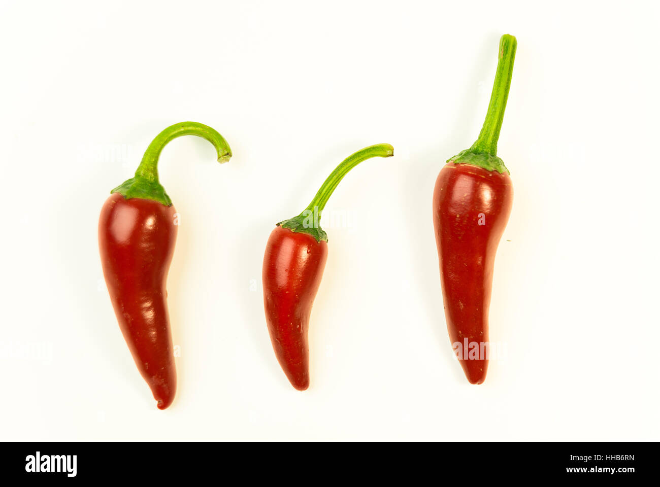 Three ripe red Chilli peppers on white Stock Photo - Alamy