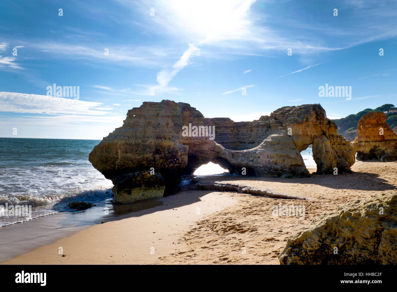 Big rock formation on Olhos De Agua beach, the sun is behind and ...