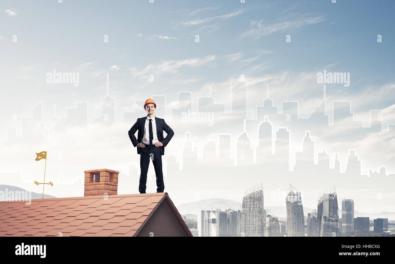 Engineer man standing on roof and looking away. Mixed media Stock Photo ...