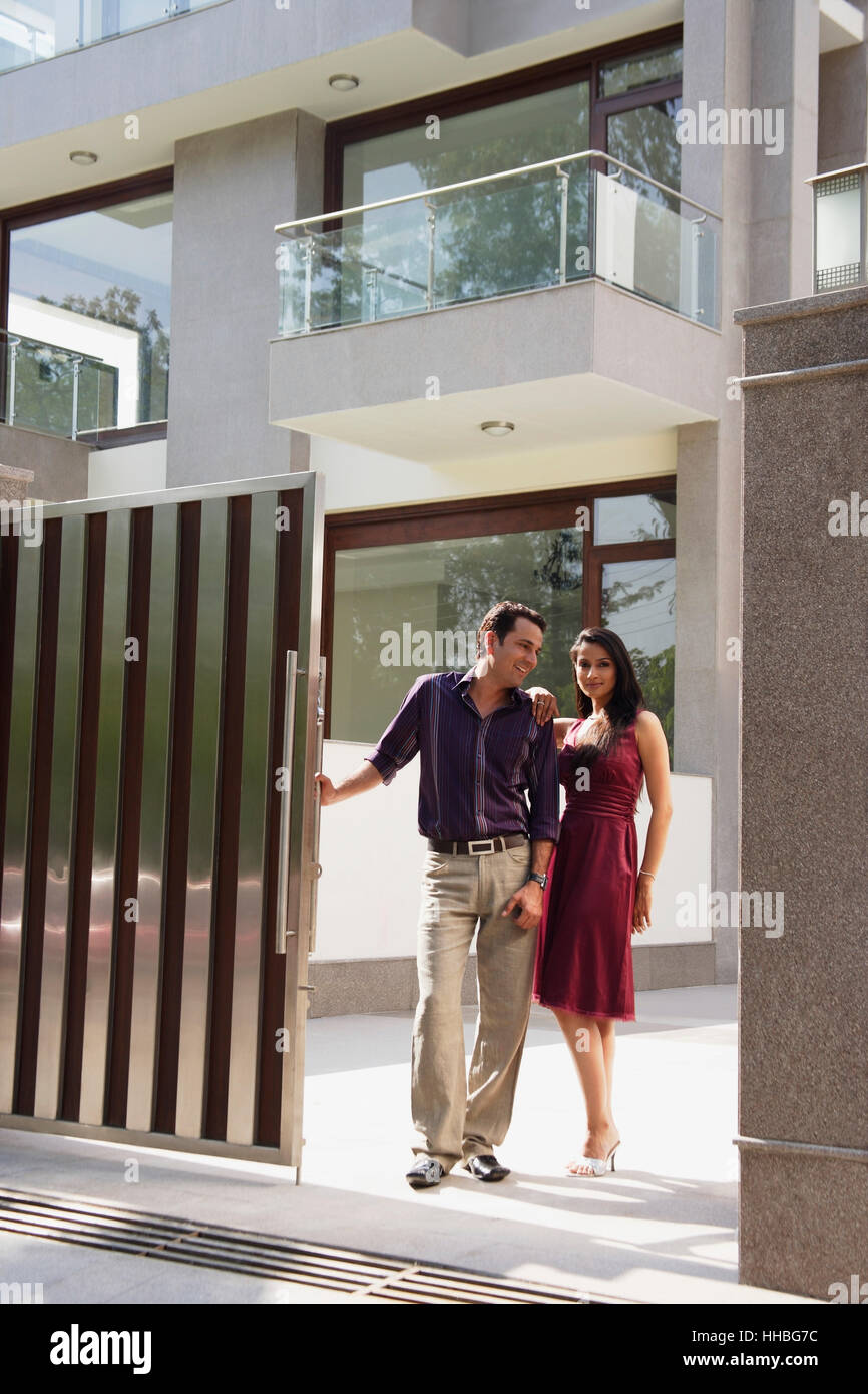 young couple standing at the gate Stock Photo - Alamy