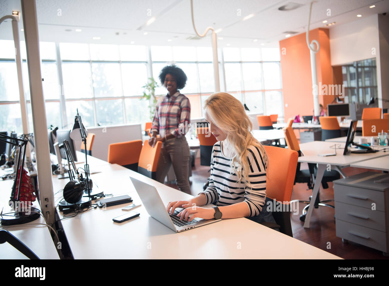 young smiling informal businesswoman working in the office with ...
