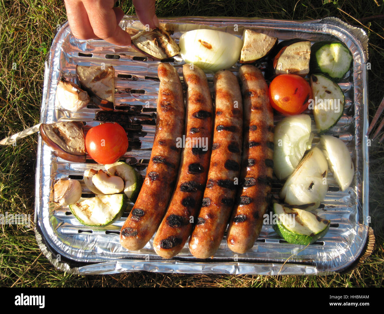 hand on a disposable barbecue with vegetables Stock Photo - Alamy