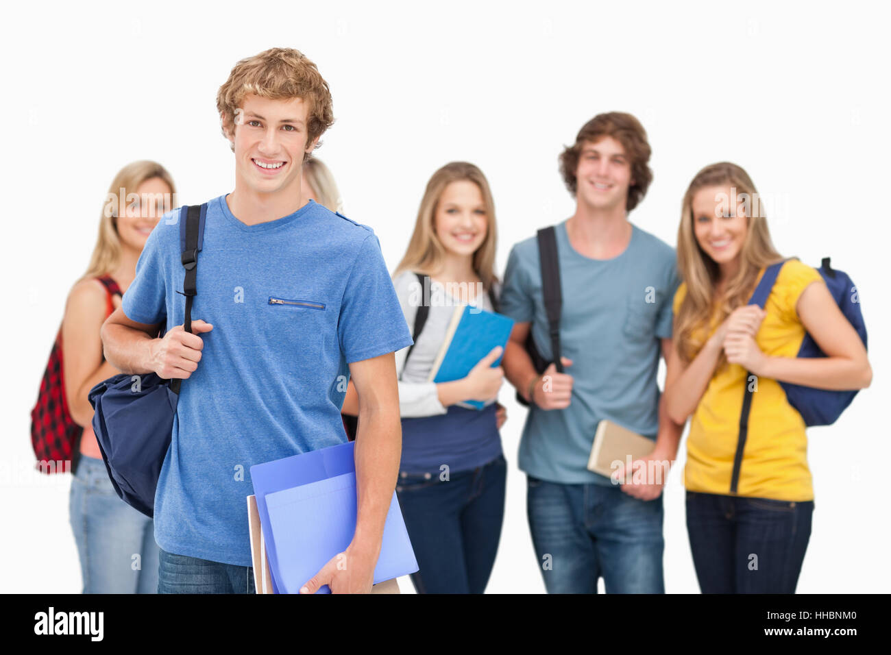 A smiling group of students all looking at the camera while one man ...