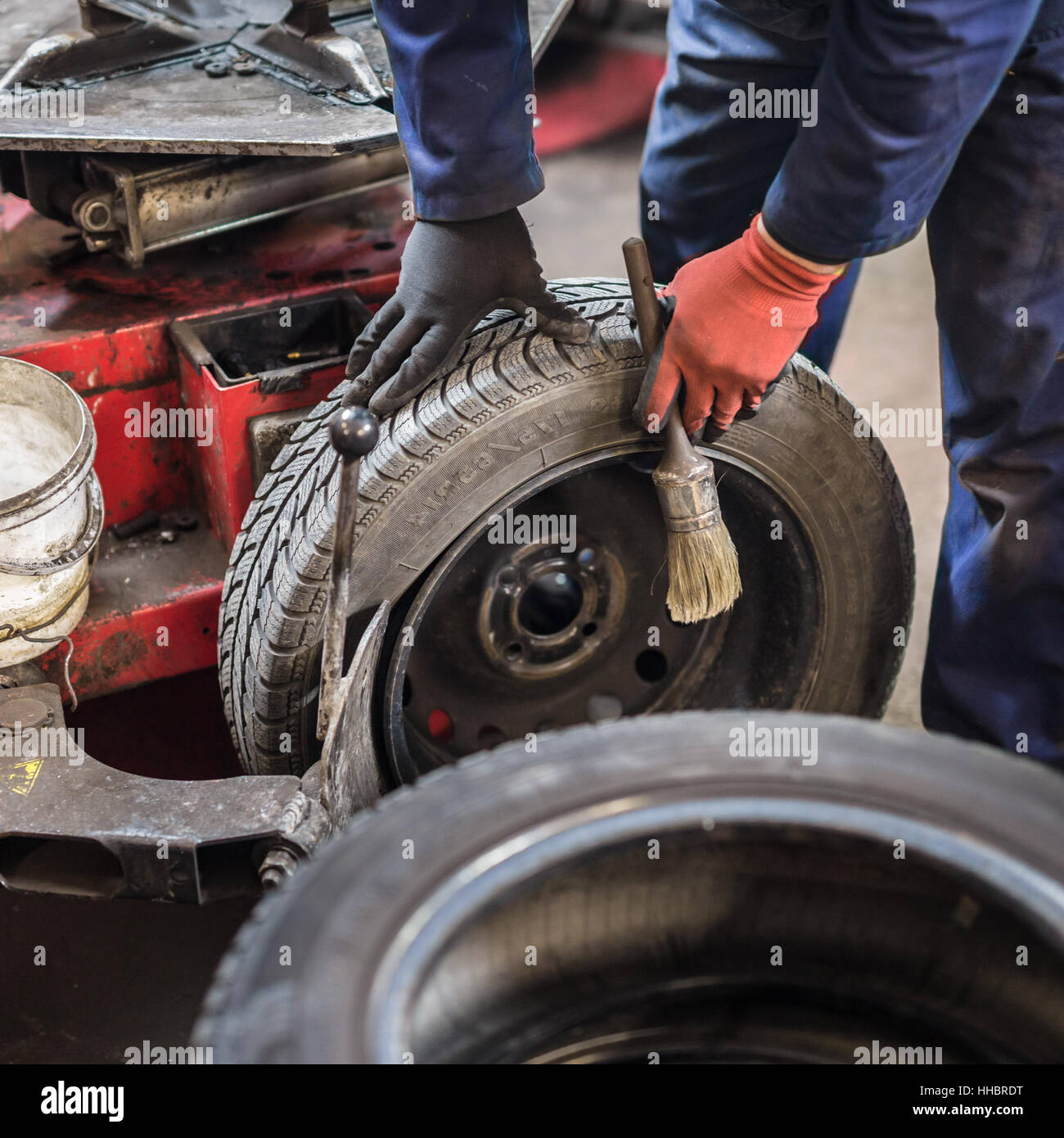 Professional auto mechanic replacing tire on wheel in car repair ...