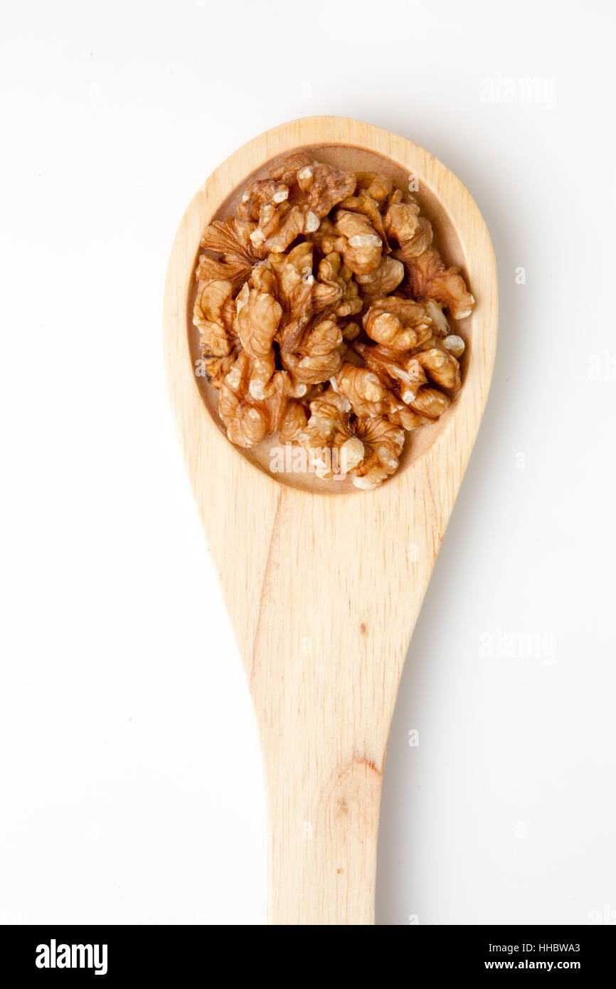 Wooden spoon with nuts against a white background Stock Photo - Alamy