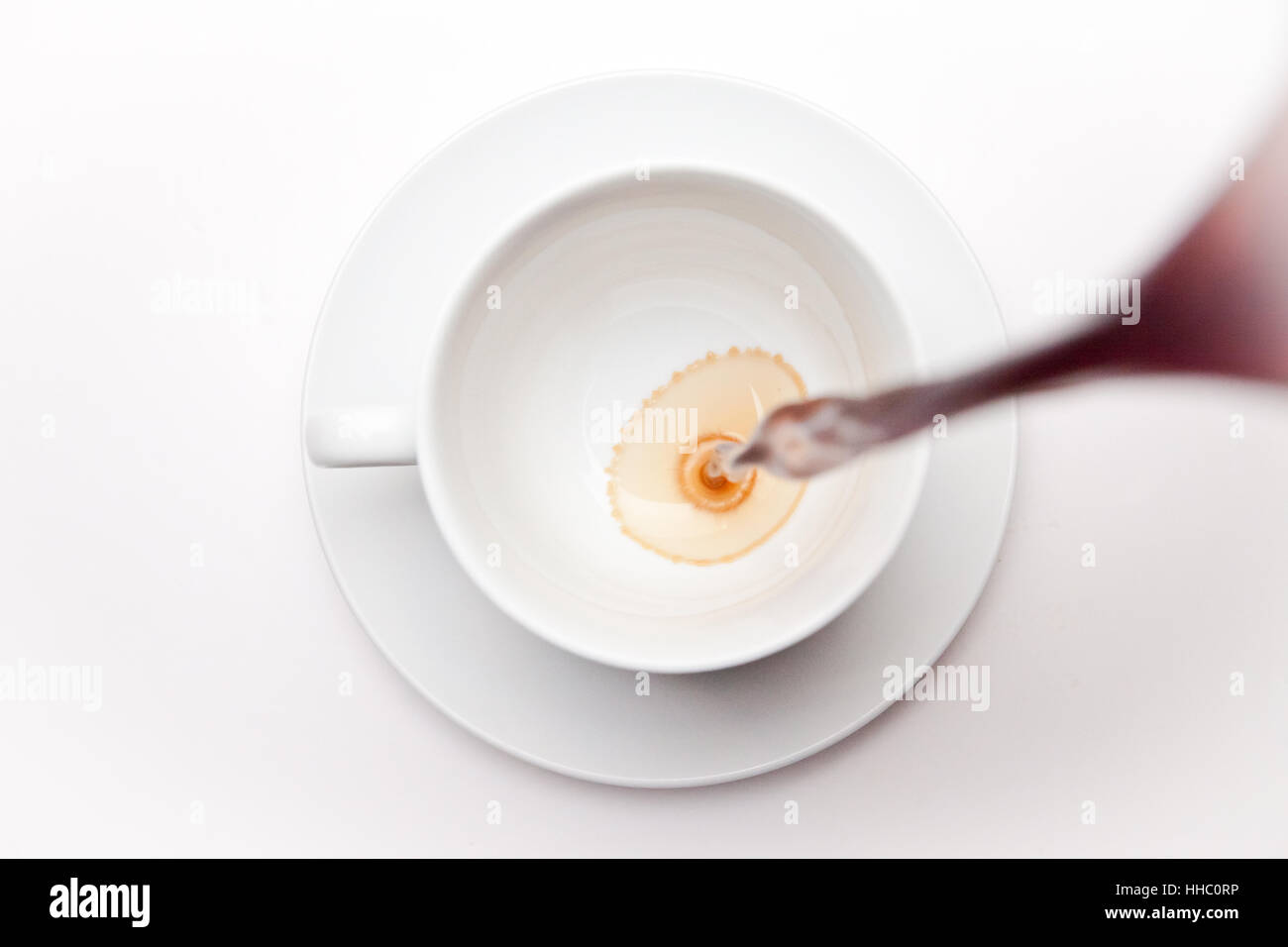 Empty coffee cup being filled against a white background Stock Photo ...