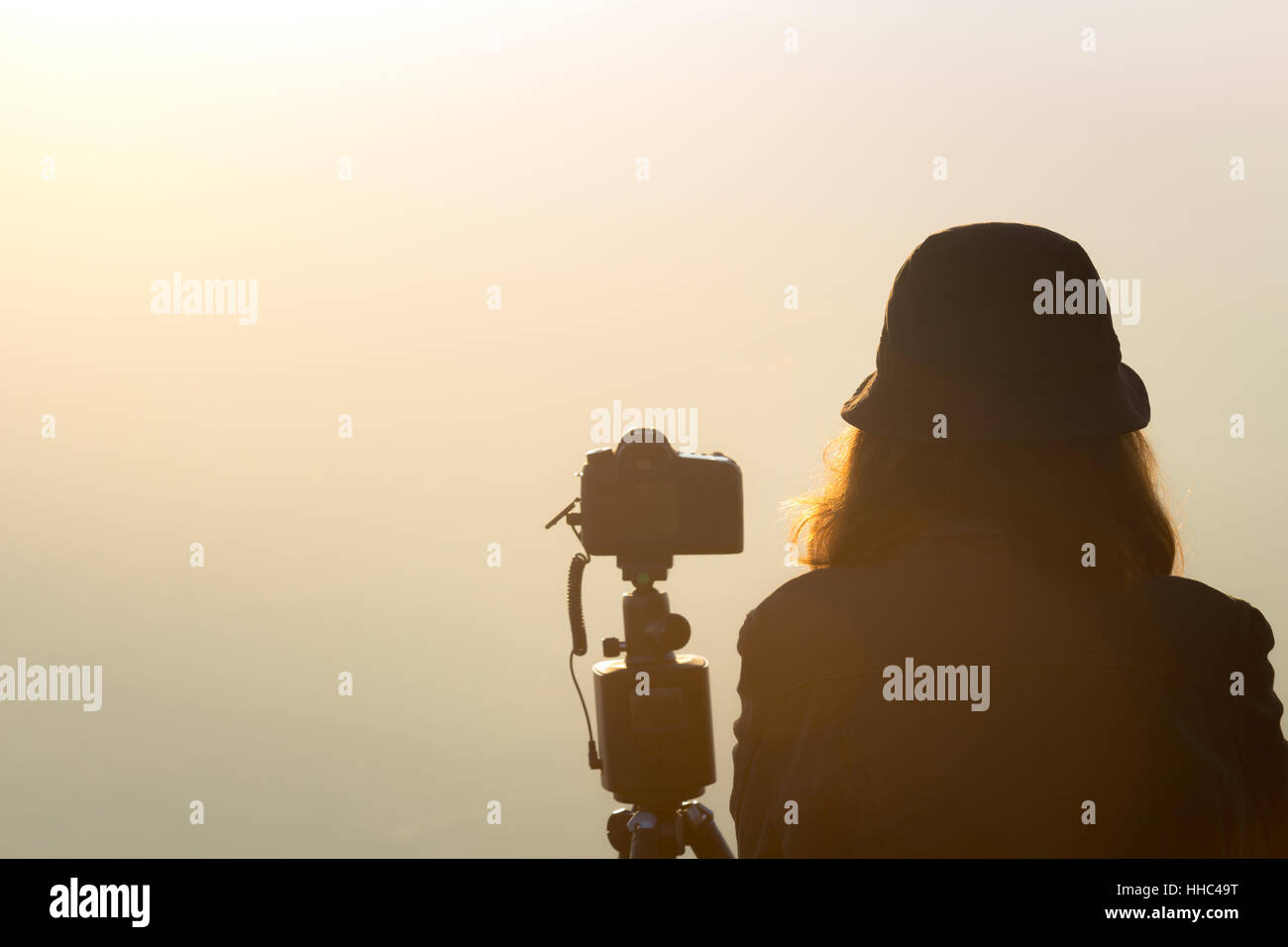 photographer woman waiting to take landscape photo in fog view during ...