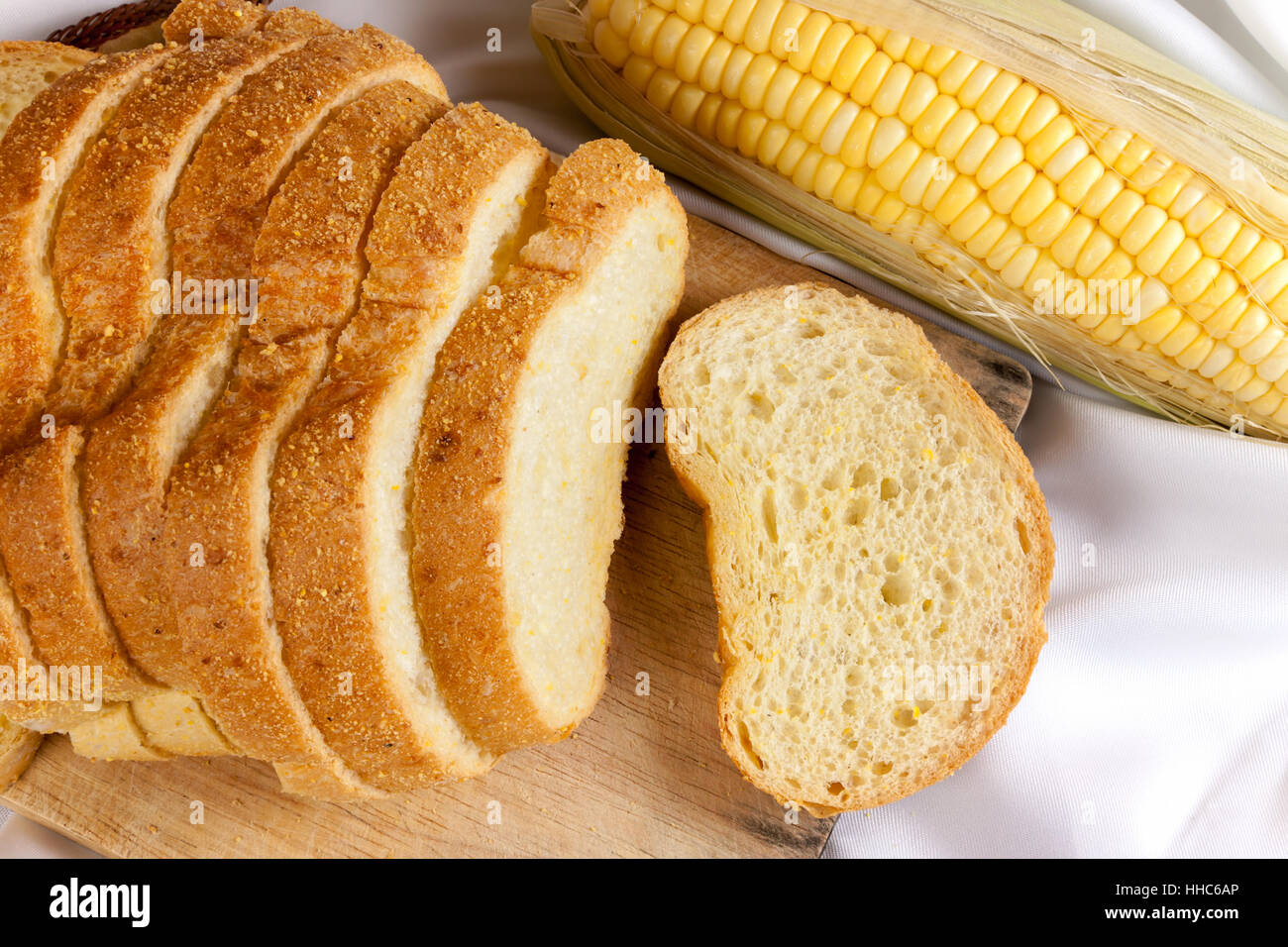 bread made from corn on the white fabric. Slices of corn bread laying ...