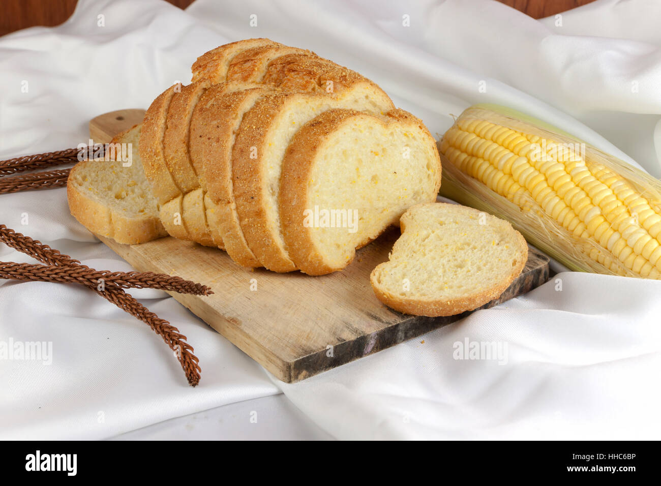 bread made from corn on the white fabric. Slices of corn bread laying ...