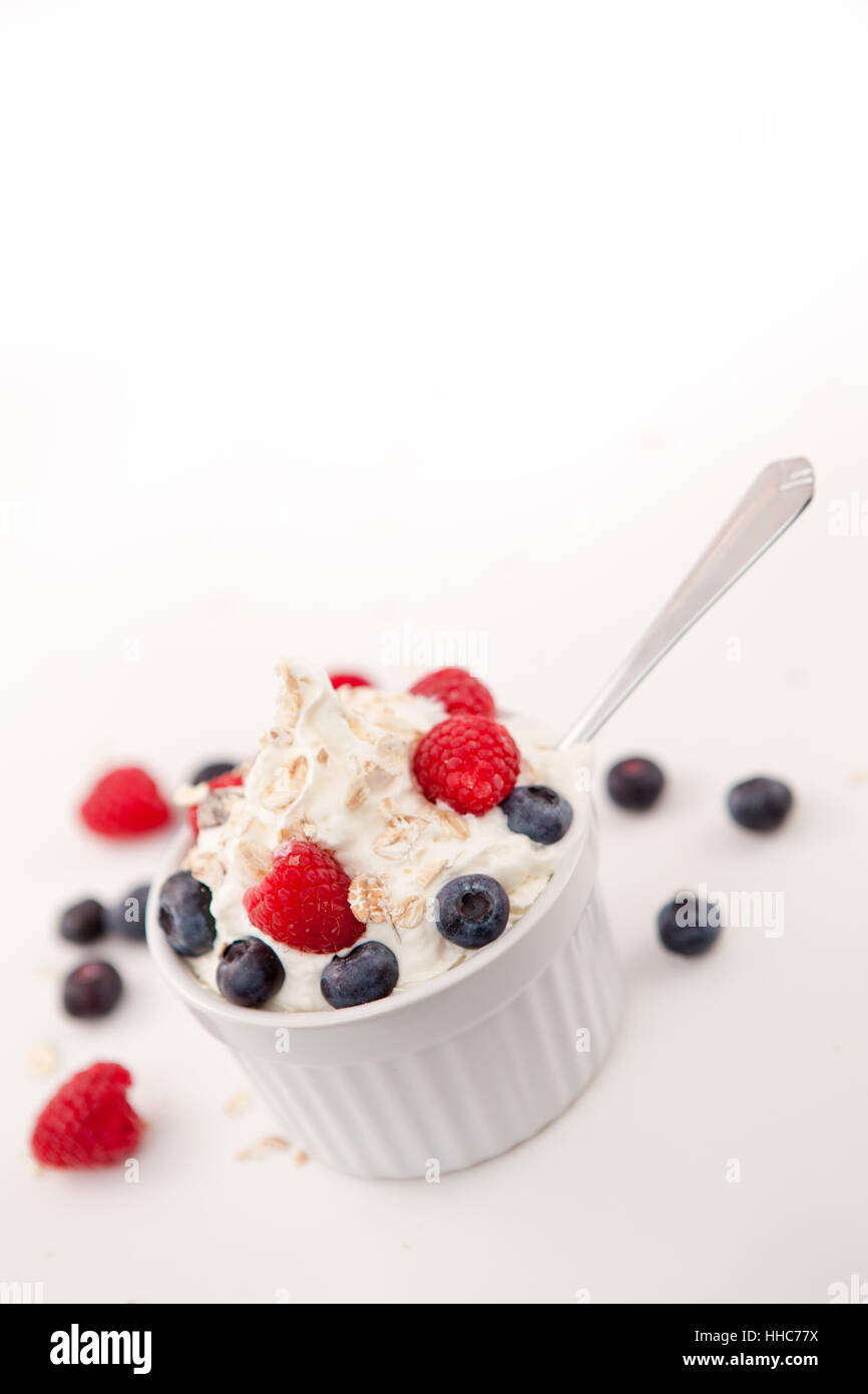 Whipped cream mix with berries against white background Stock Photo - Alamy