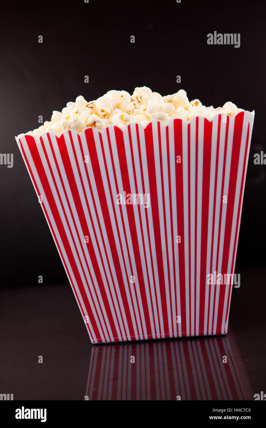 Full box of pop corn on a black table against a black background Stock ...