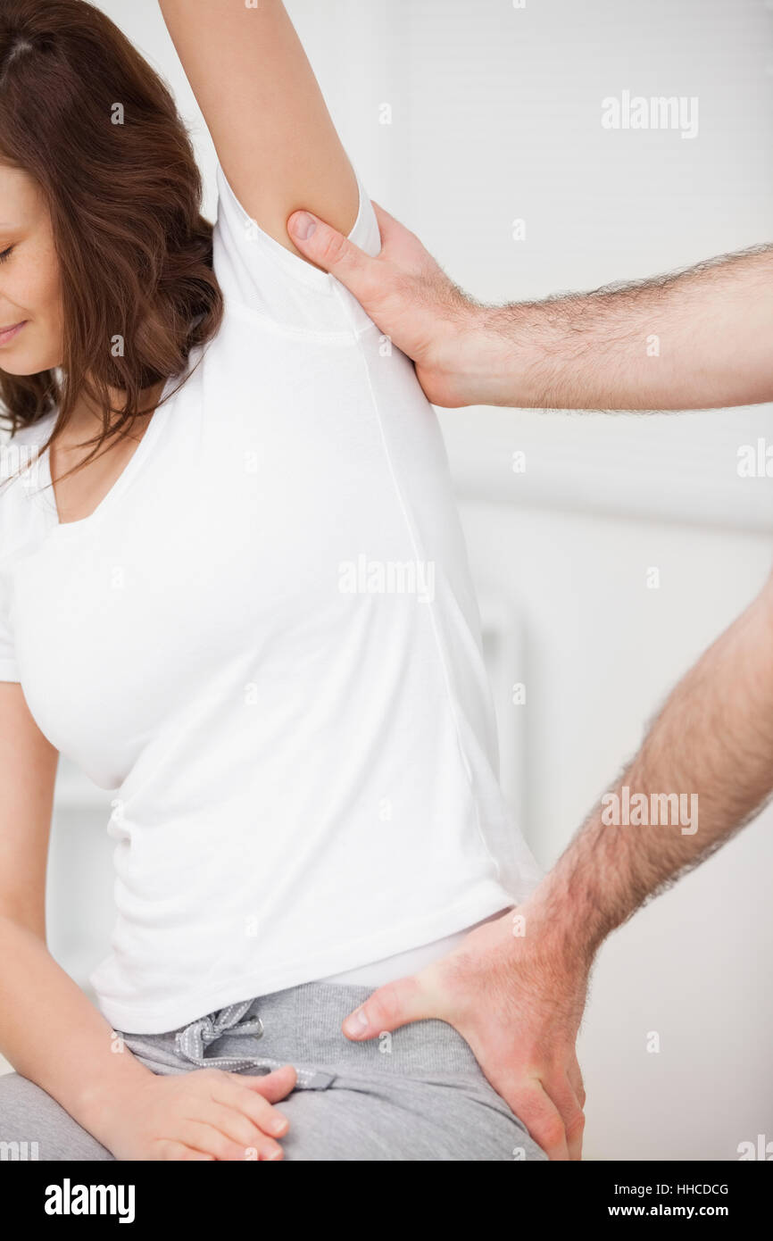 Close-up of a woman being stretched while sitting in a room Stock Photo ...