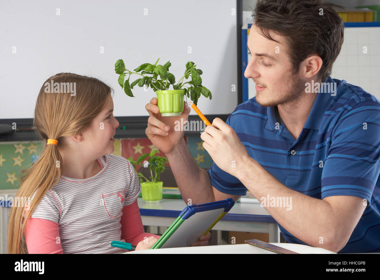 Girl learning about plants with teacher Stock Photo - Alamy