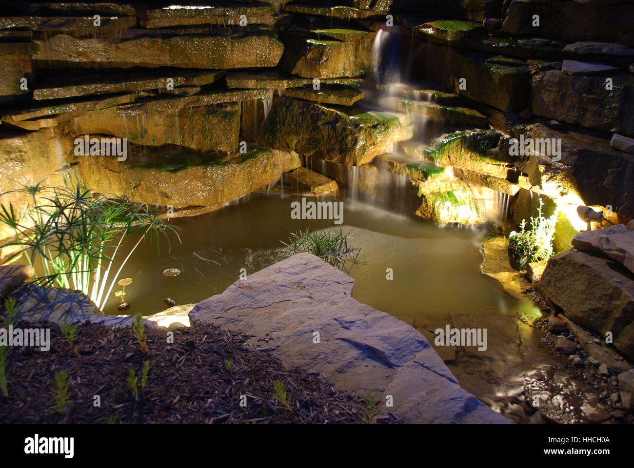 Outdoor lighting illuminates a residential waterfall landscape Stock ...