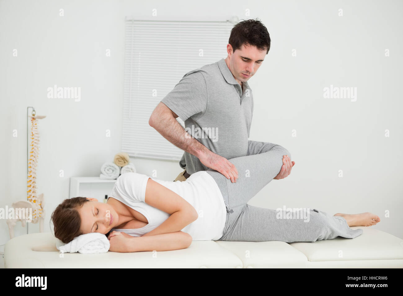 Leg of a woman being manipulated by a chiropractor in a medical room ...