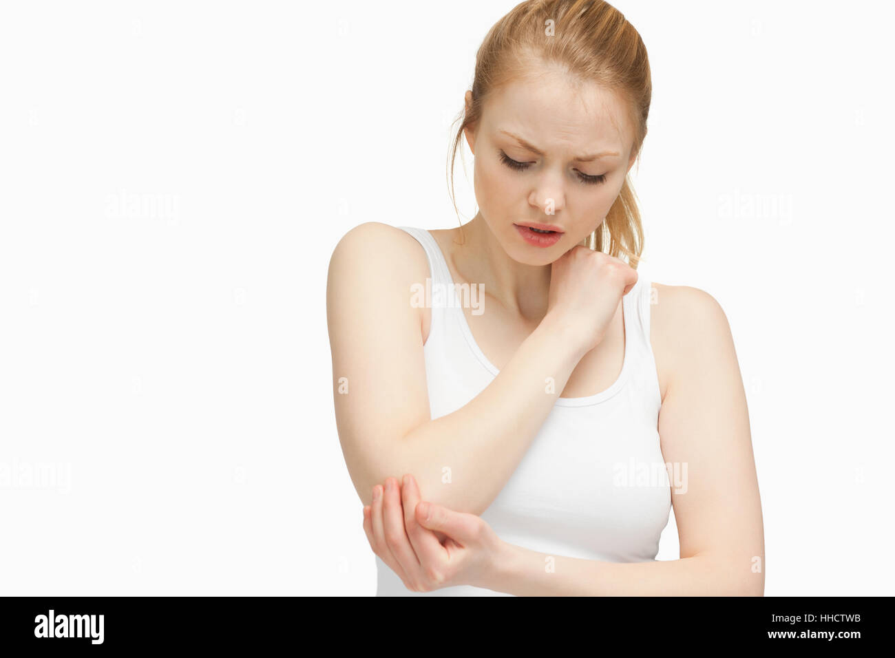 Young woman touching her elbow against white background Stock Photo - Alamy