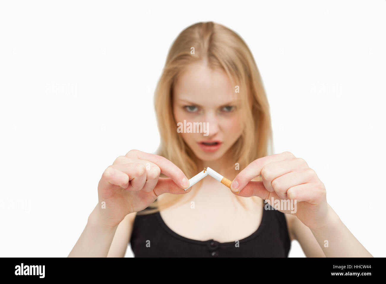 Angry woman braking a cigarette against white background Stock Photo ...