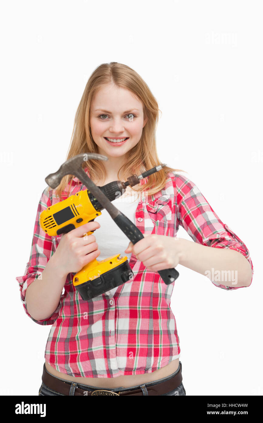 Young woman holding tools against white background Stock Photo - Alamy