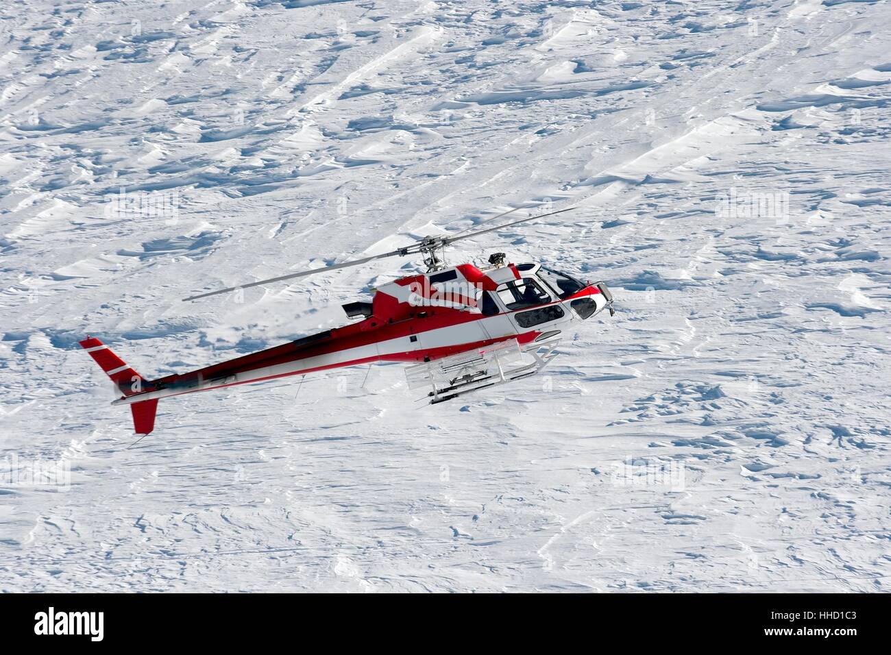 Rescue helicopter flying above snow covered mountains Stock Photo - Alamy
